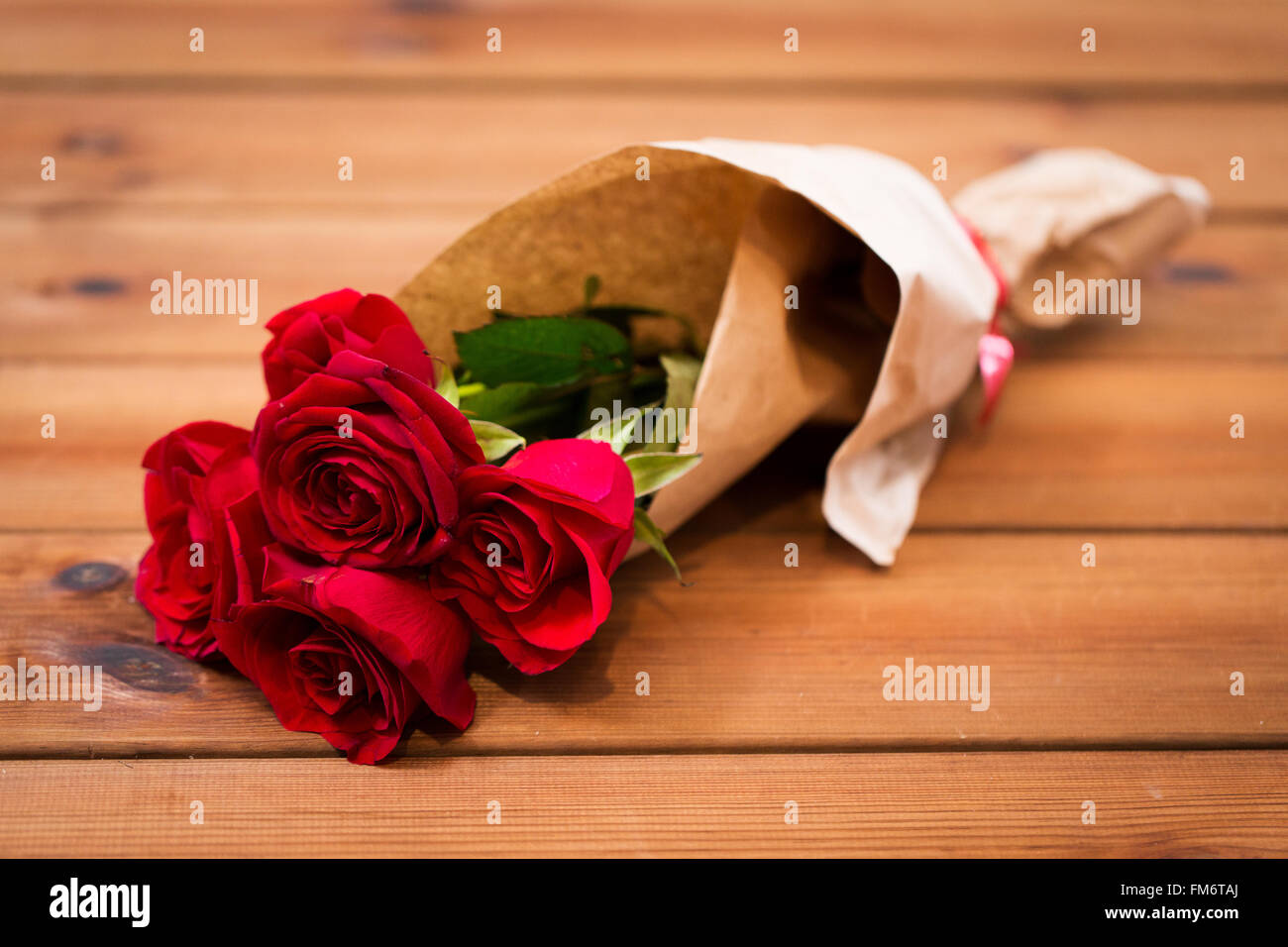 close up of red roses bunch wrapped into paper Stock Photo - Alamy