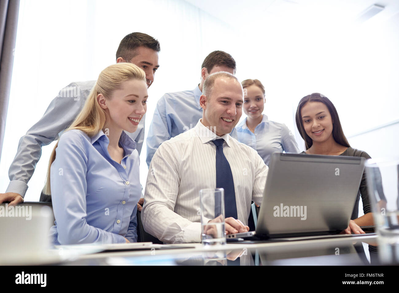 smiling business people with laptop in office Stock Photo - Alamy