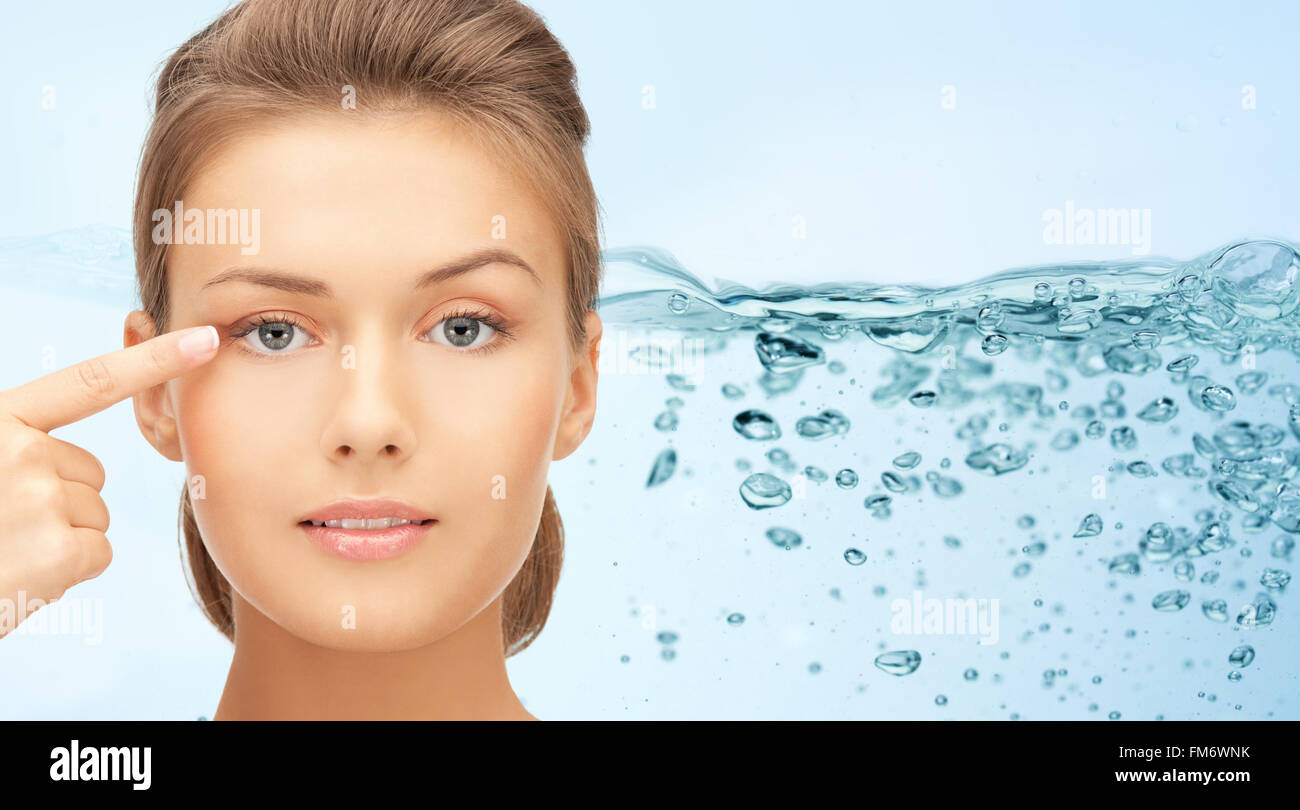 face of young woman pointing finger to her eye Stock Photo - Alamy