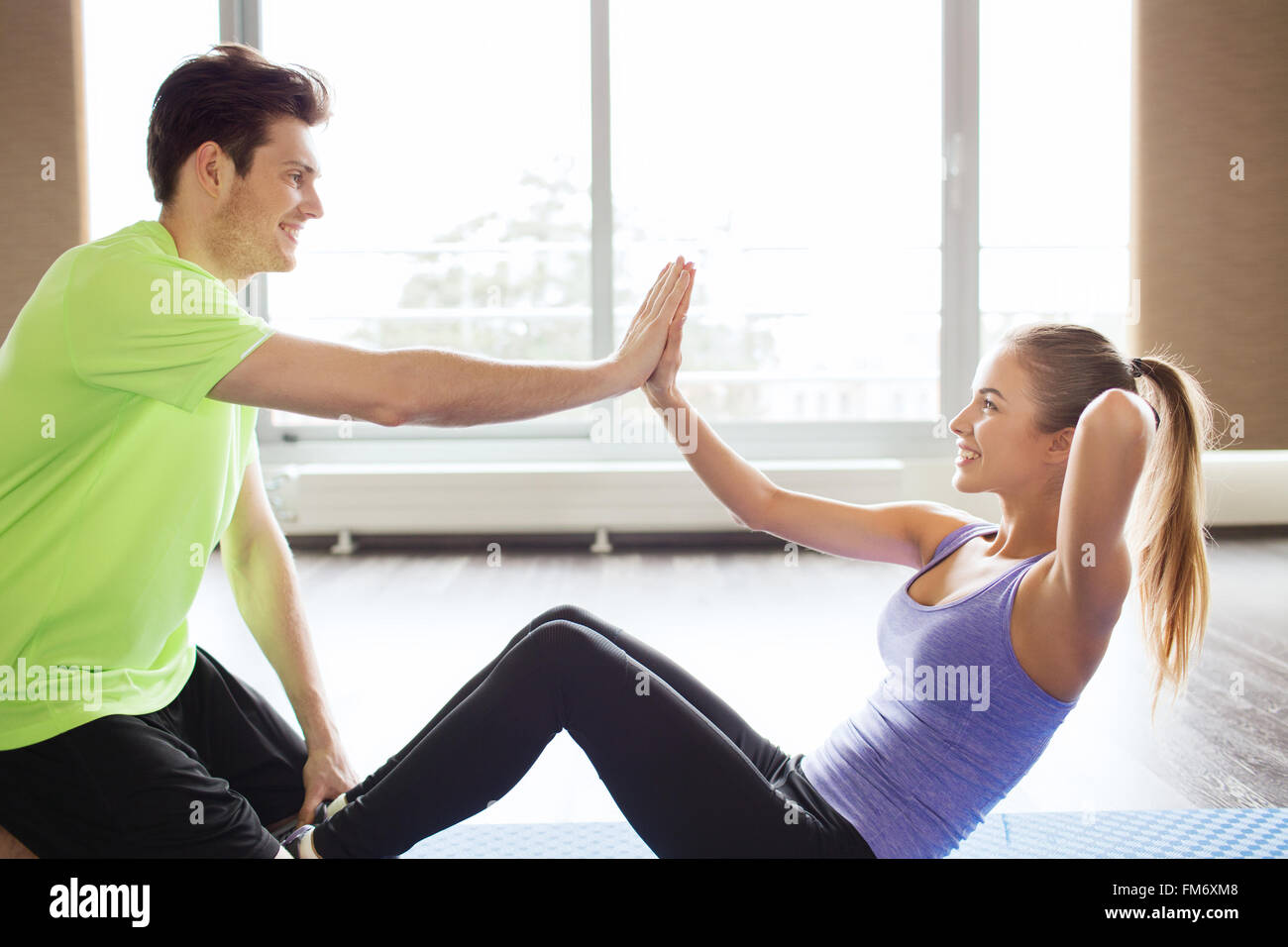 woman with personal trainer doing sit ups in gym Stock Photo - Alamy