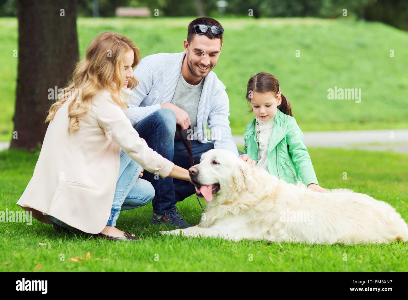 happy family with labrador retriever dog in park Stock Photo - Alamy