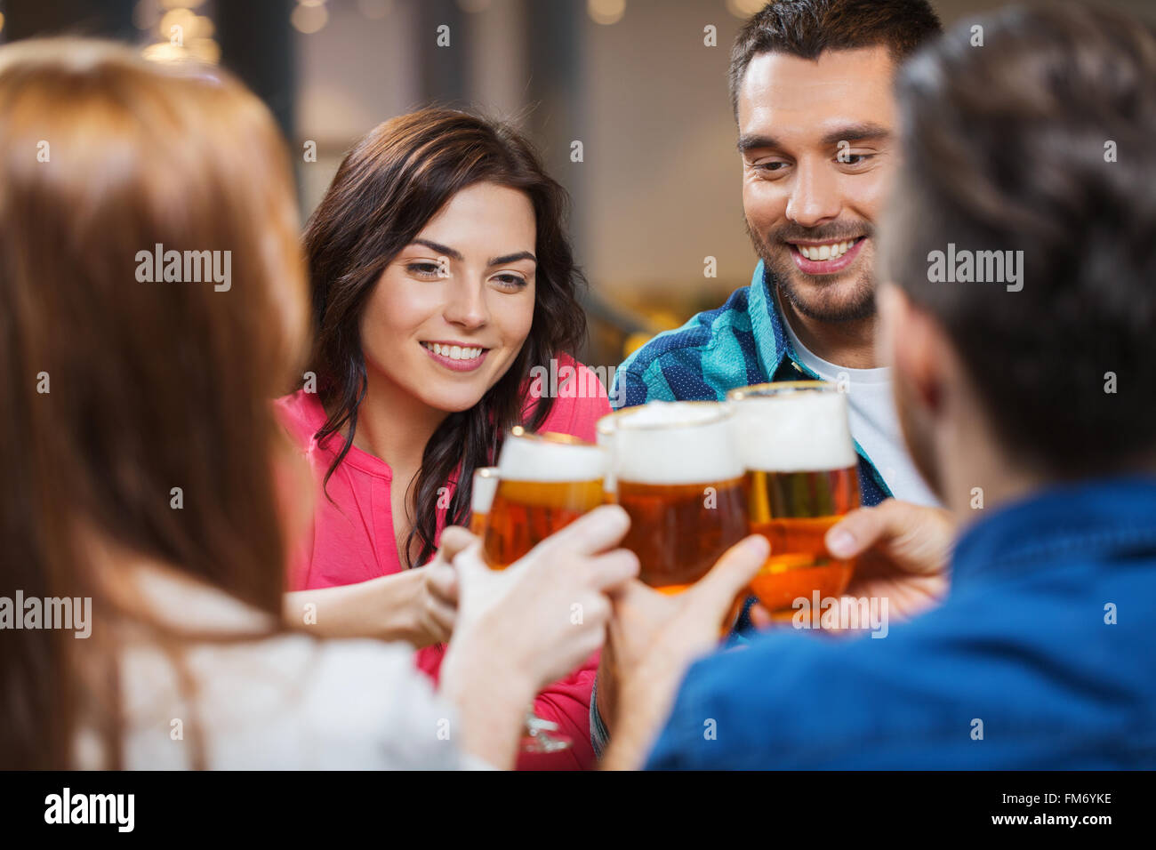 friends drinking beer and clinking glasses at pub Stock Photo - Alamy