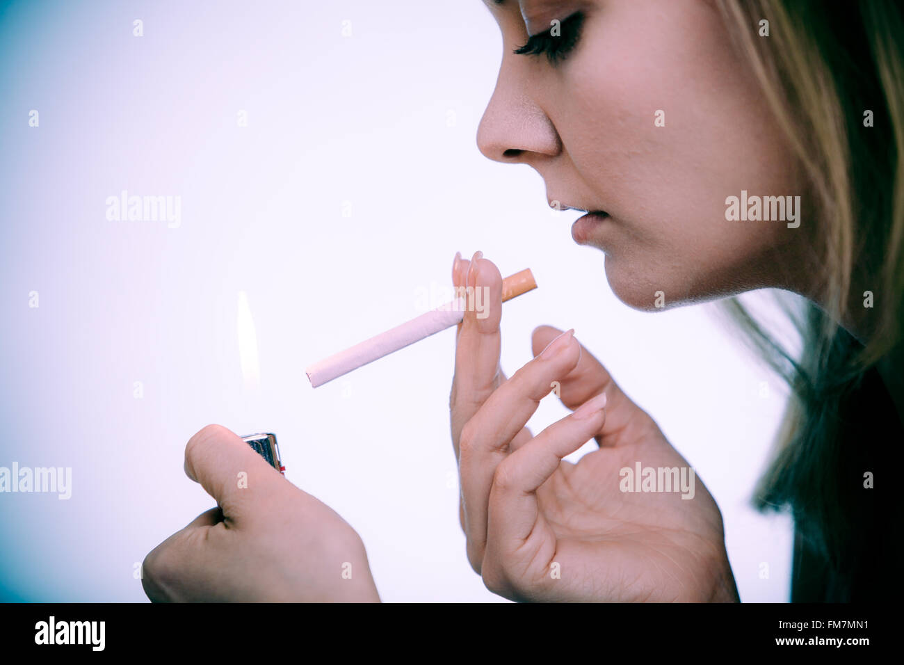 Addiction. Young woman with lighter lighting up cigarette. Addicted ...