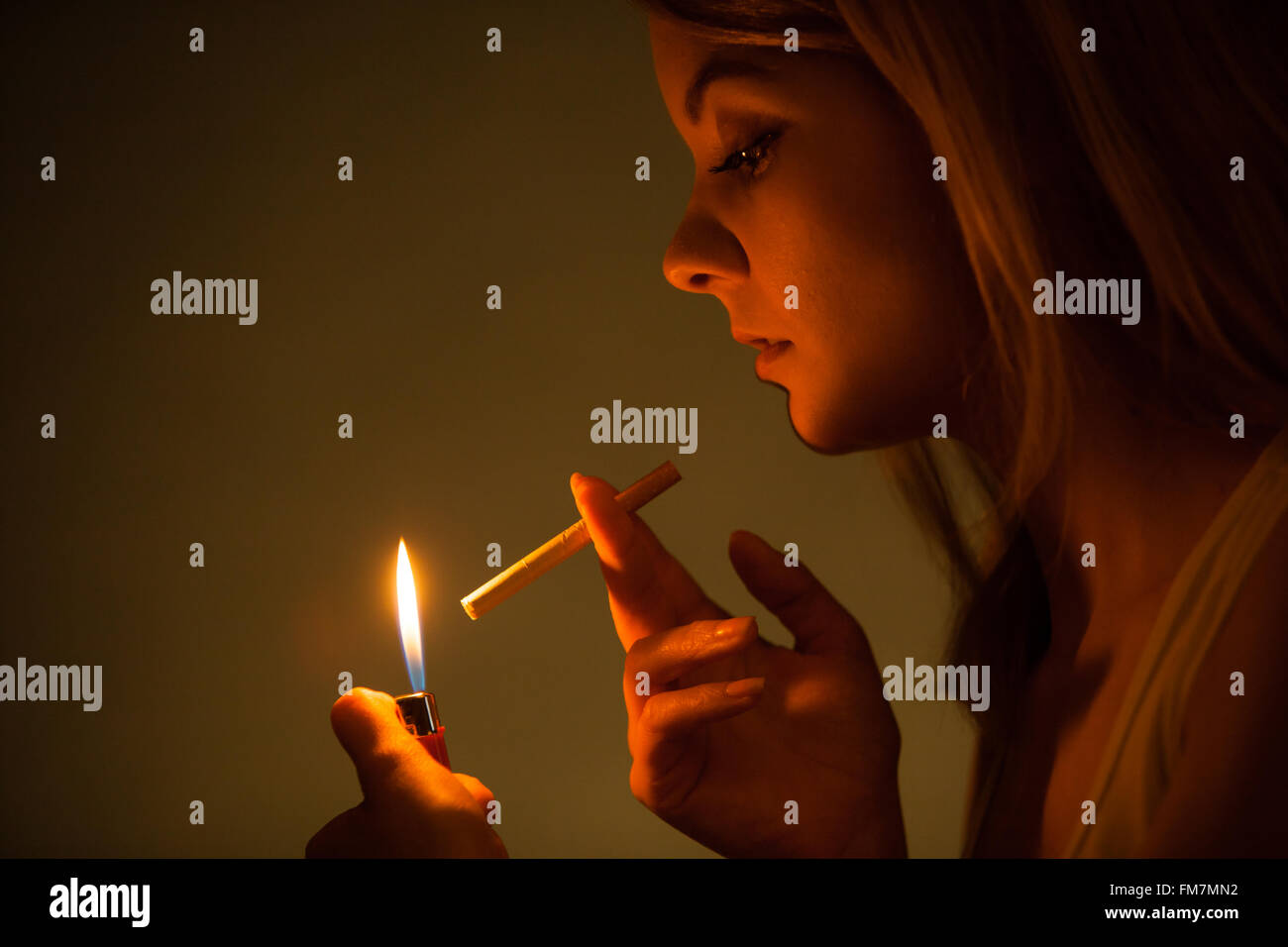 Addiction. Young woman with lighter lighting up cigarette. Addicted ...