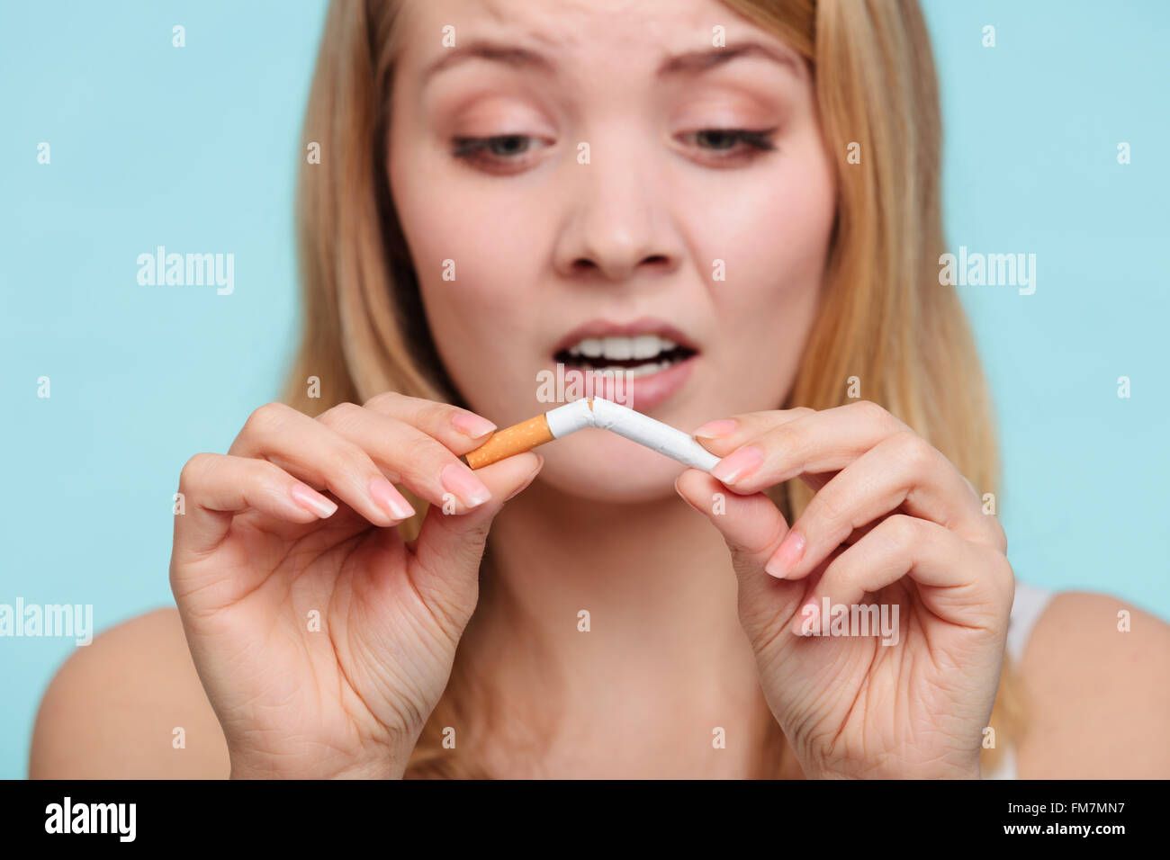 Disappointed pretty girl at breaking up with cigarette. Addicted ...