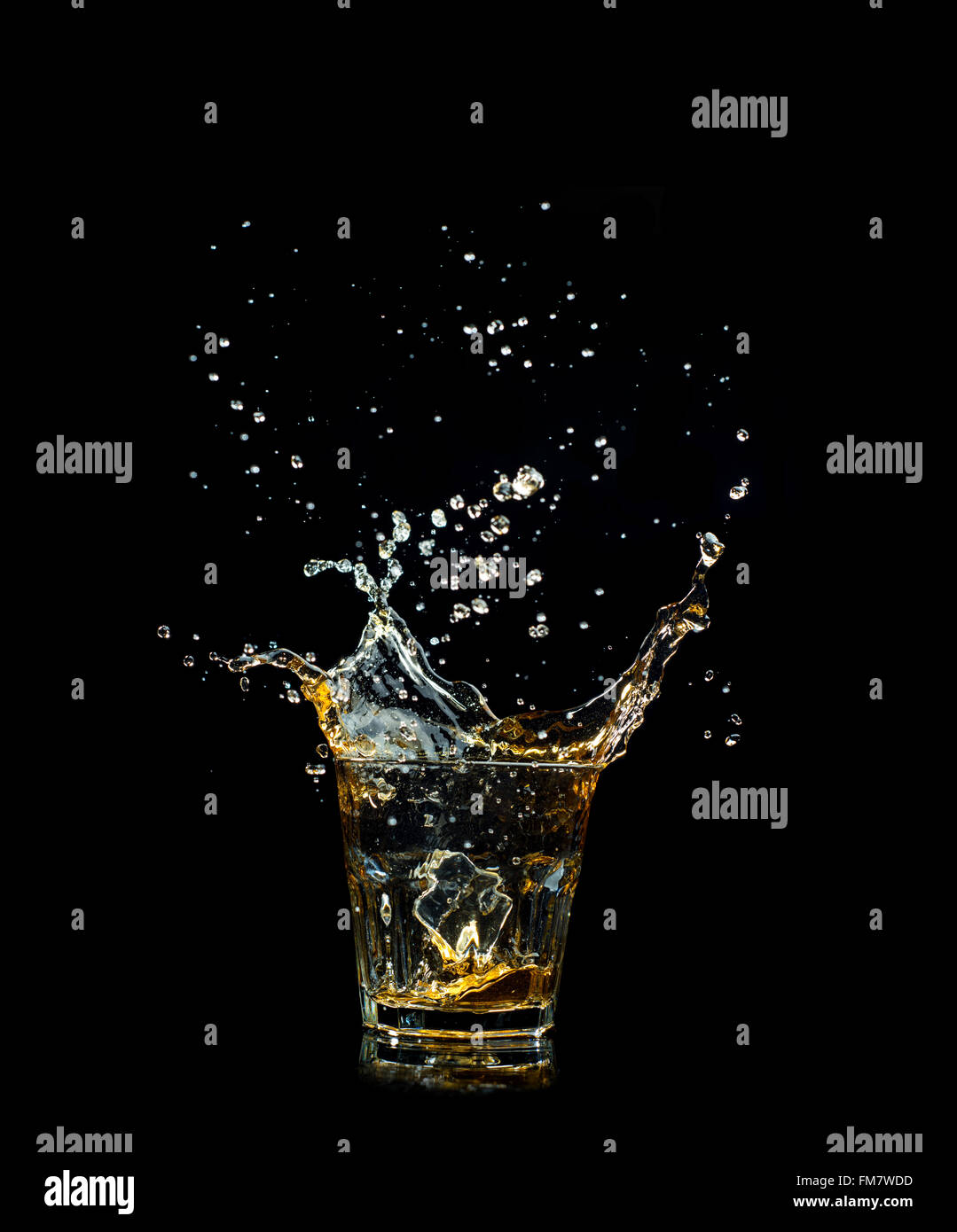 Whiskey splash in glass isolated on black background Stock Photo - Alamy