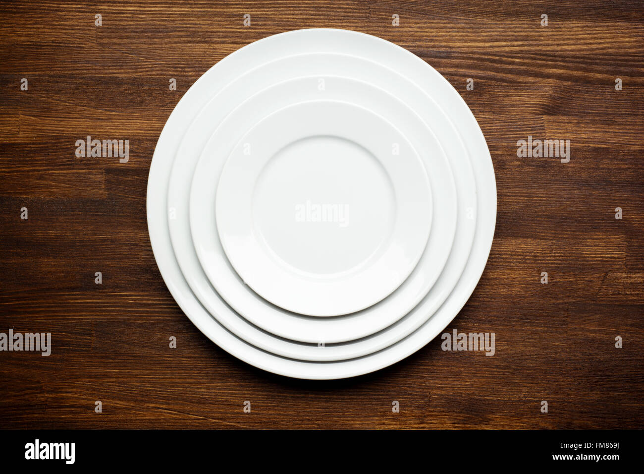 Empty white plates on rustic wooden background Stock Photo - Alamy