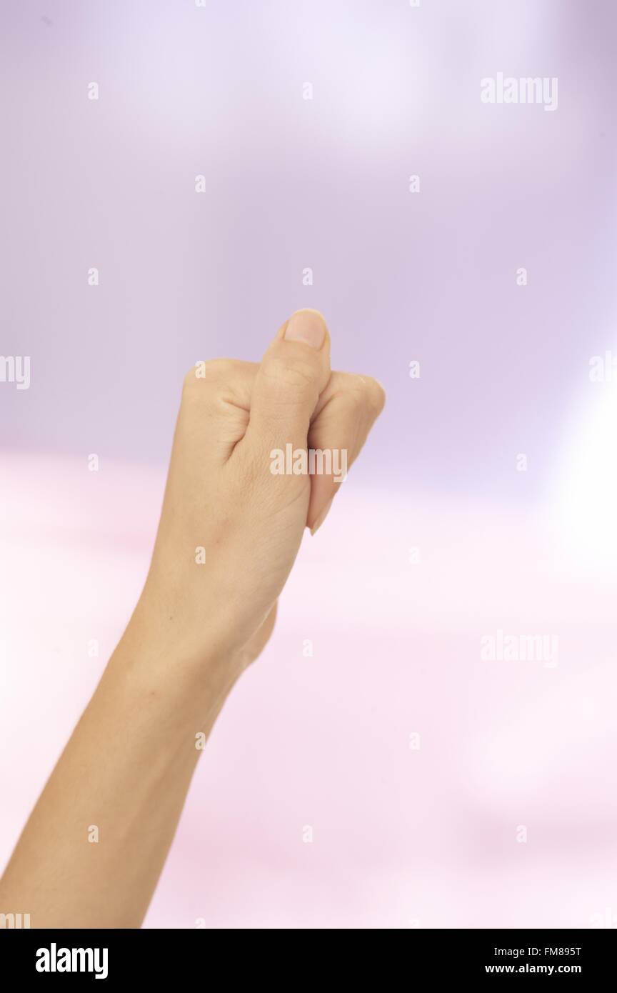 Curling fingers over to touch palm, curling thumb over fingers to make ...