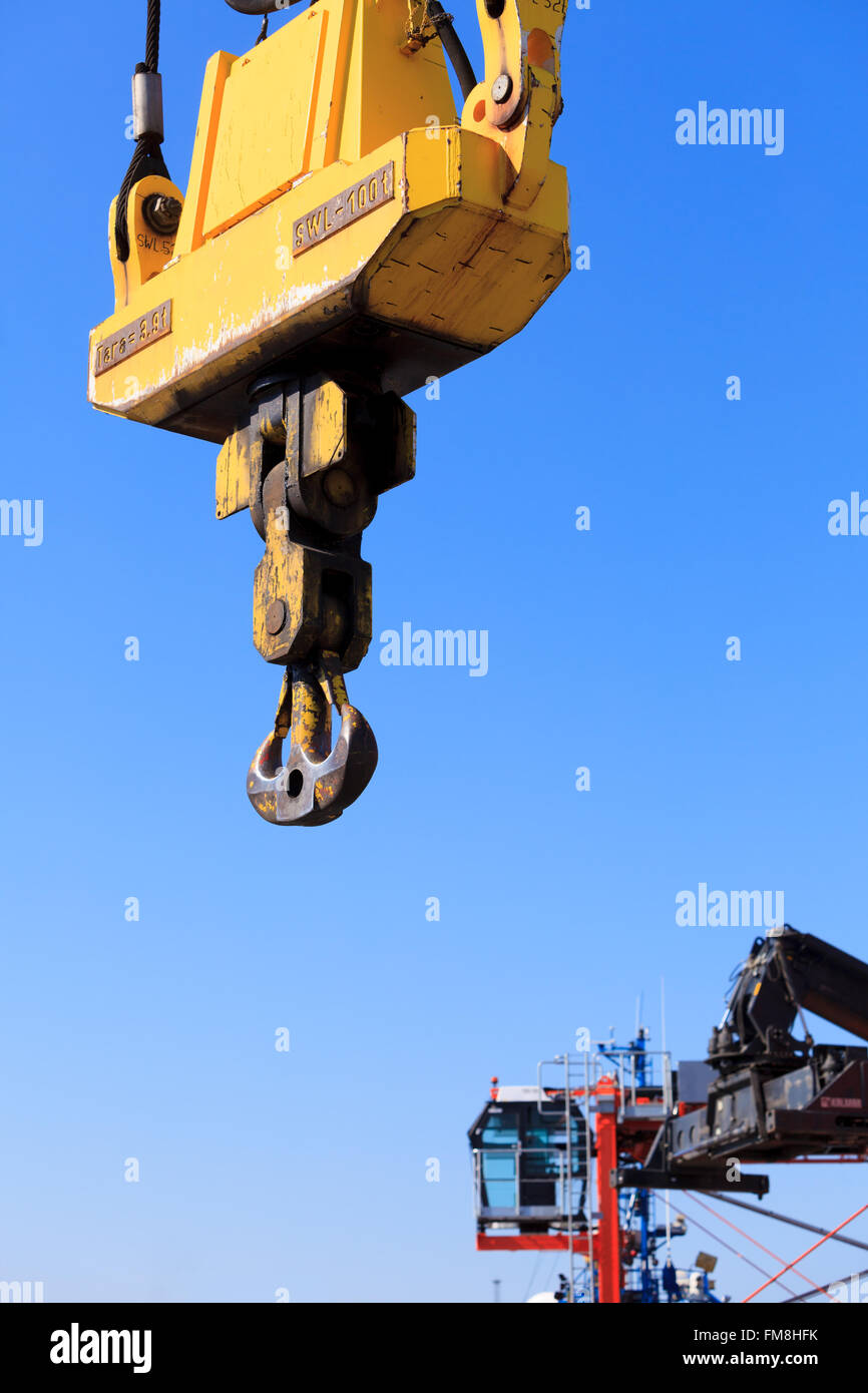 Business and commerce. Closeup crane hook at port area and blue sky ...