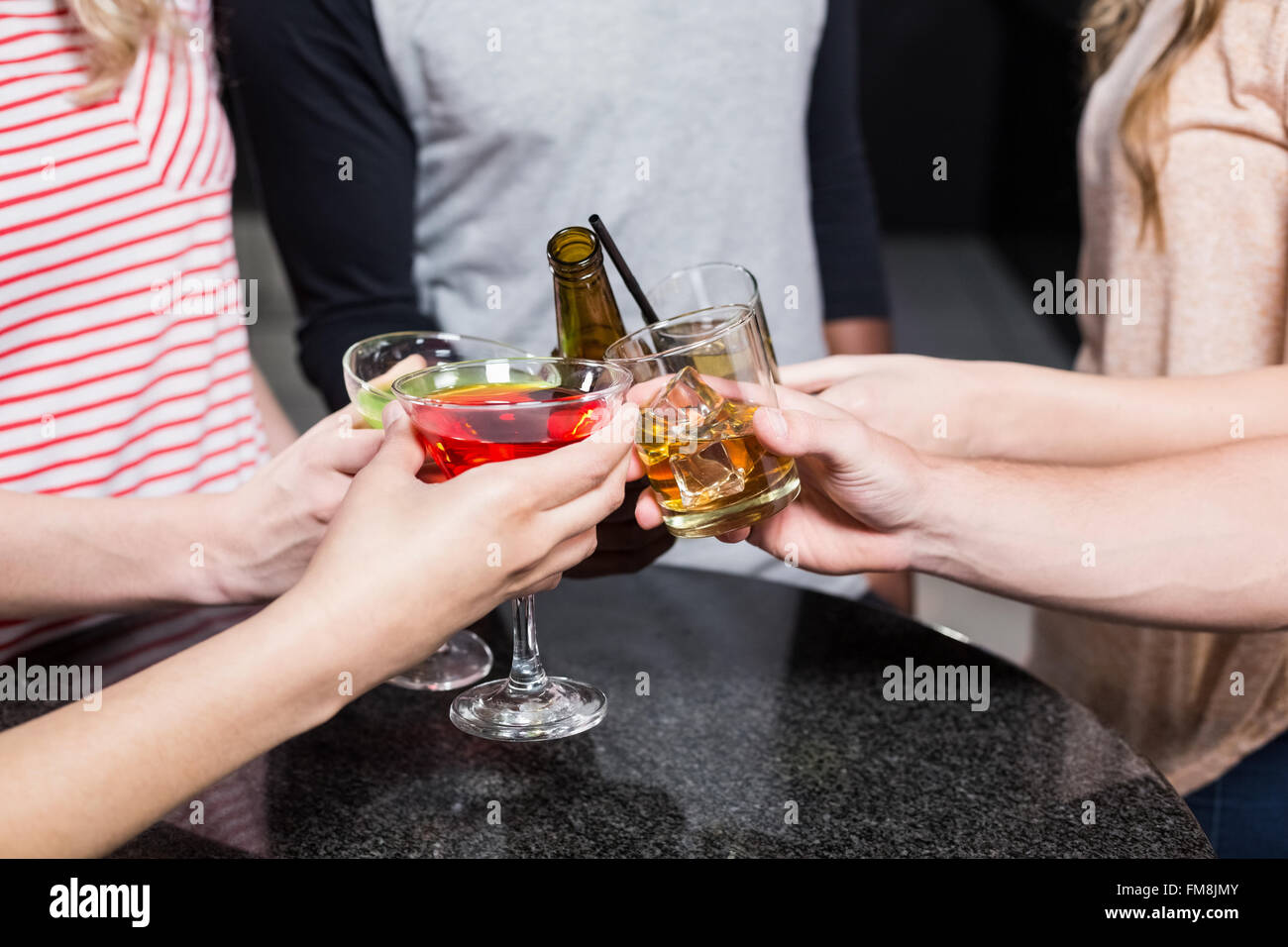 Group of friends toasting with beer and cocktails Stock Photo - Alamy