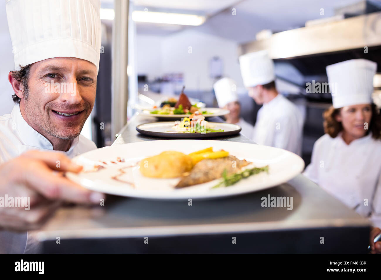 Smiling male chef handing hi-res stock photography and images - Alamy