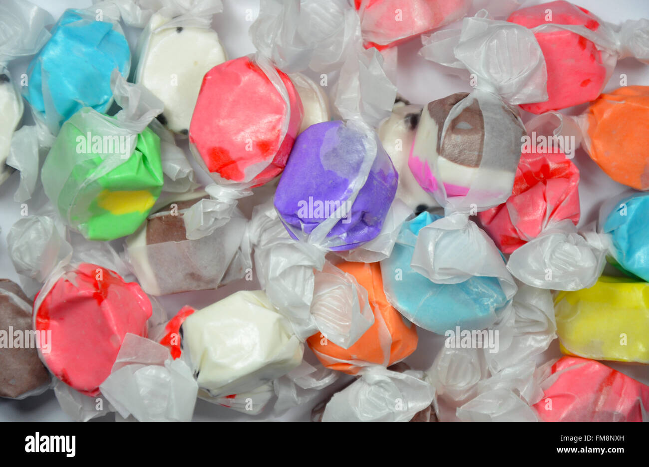 Colorful wrapped taffy candy on white background Stock Photo - Alamy