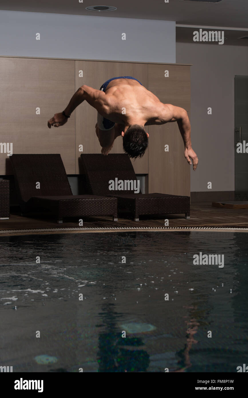 Young Man Jumping Into The Water Swimming Pool Stock Photo - Alamy