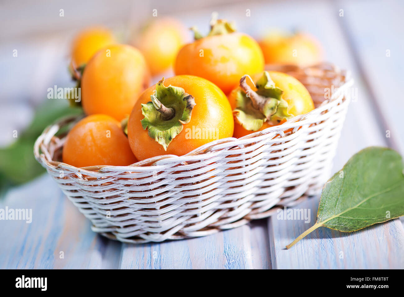 persimmon in basket and on a table Stock Photo - Alamy
