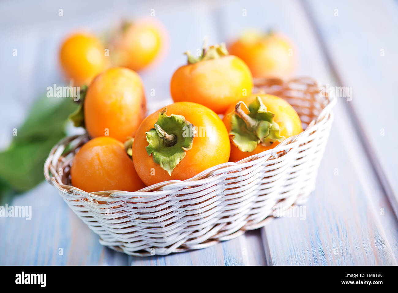 persimmon in basket and on a table Stock Photo - Alamy