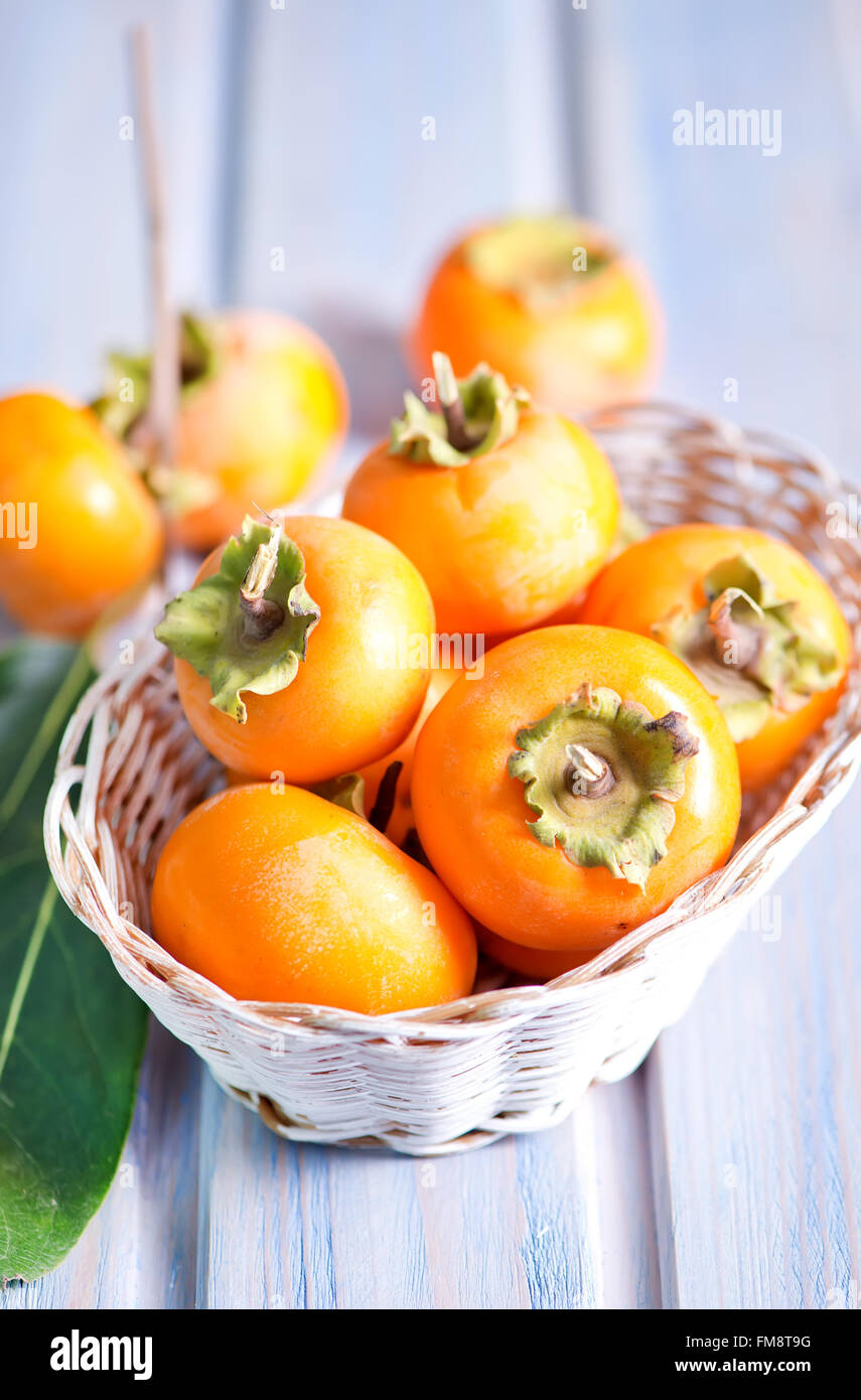 persimmon in basket and on a table Stock Photo - Alamy