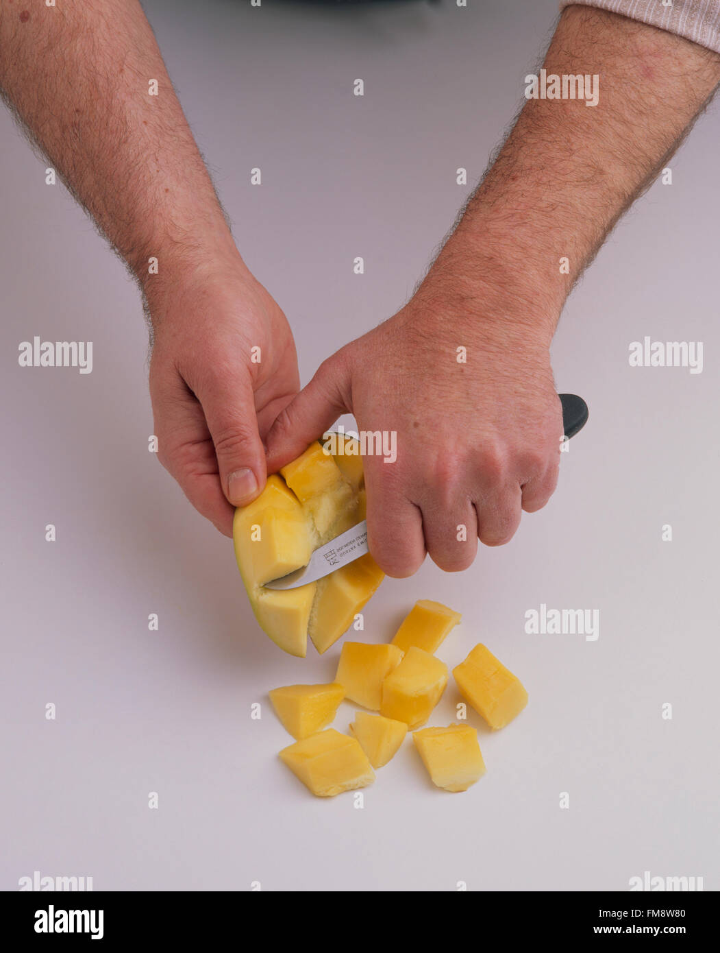 Mango cut with Knife into Chunks Stock Photo - Alamy