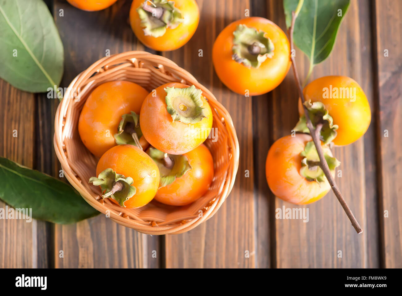 persimmon in basket and on a table Stock Photo - Alamy