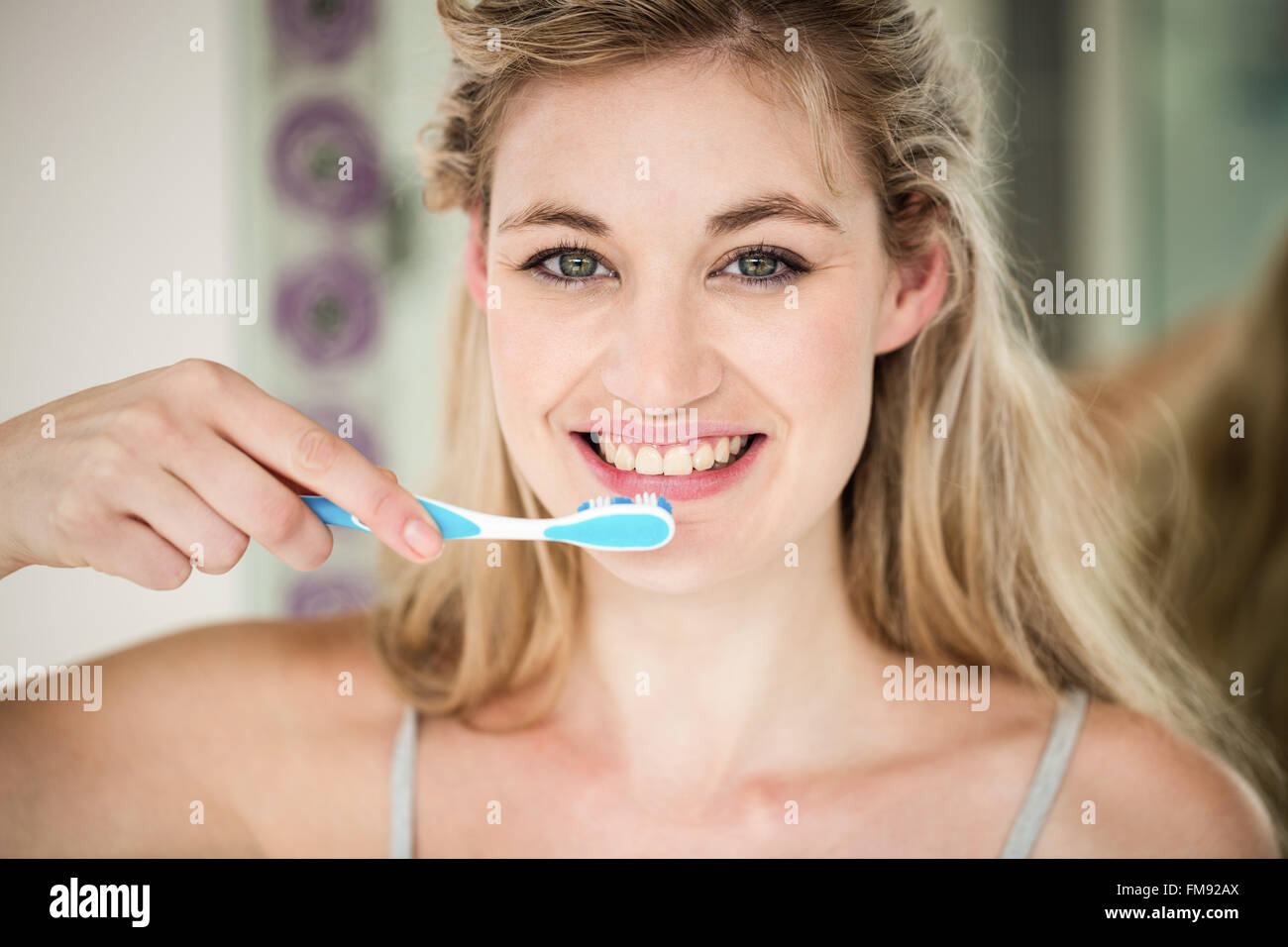 Portrait of smiling woman brushing teeth Stock Photo - Alamy