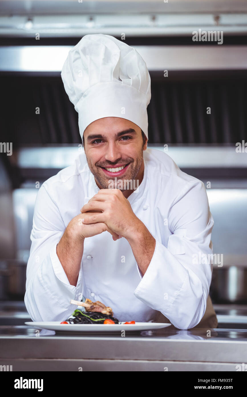 Chef leaning on the counter with a dish Stock Photo - Alamy