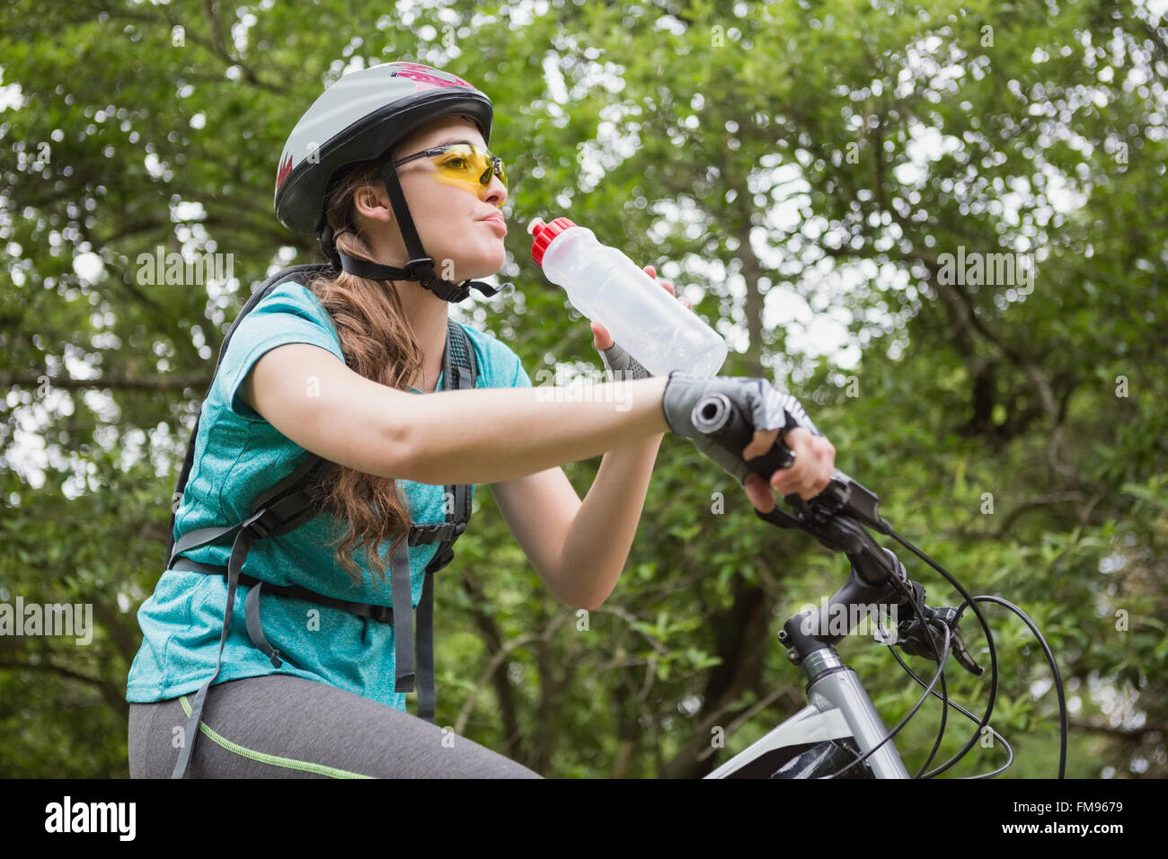 Woman drinking water while cycling Stock Photo - Alamy