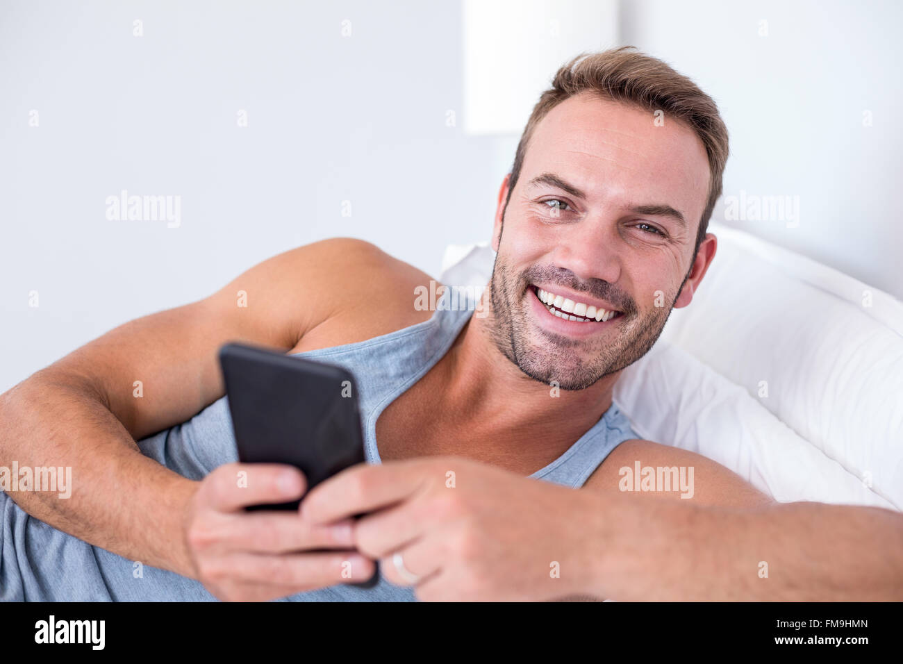 Young man lying on bed Stock Photo - Alamy