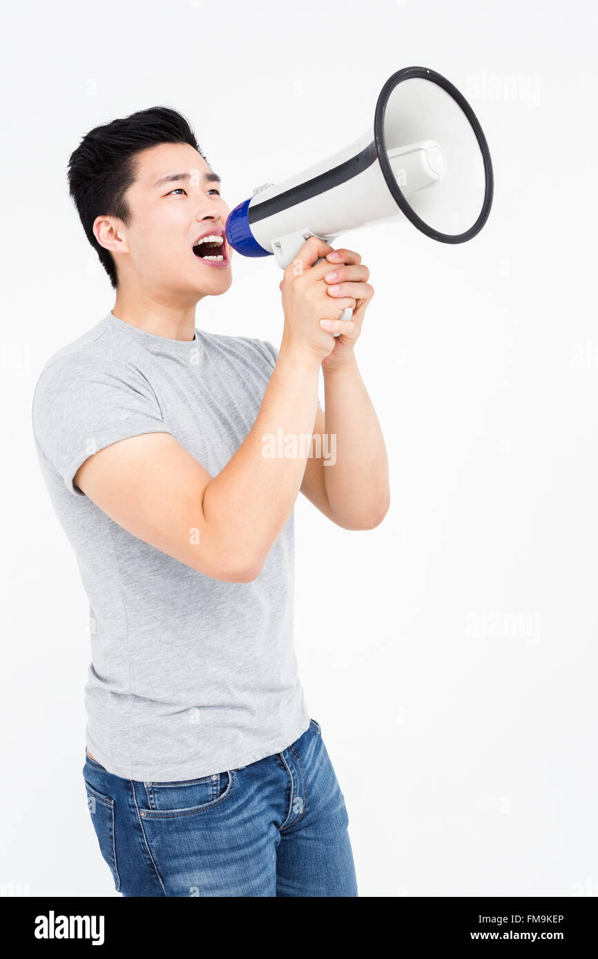 Young man shouting on horn loudspeaker Stock Photo - Alamy
