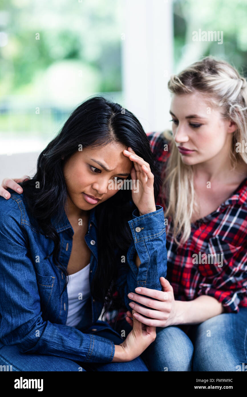 Young woman consoling depressed female friend at home Stock Photo - Alamy