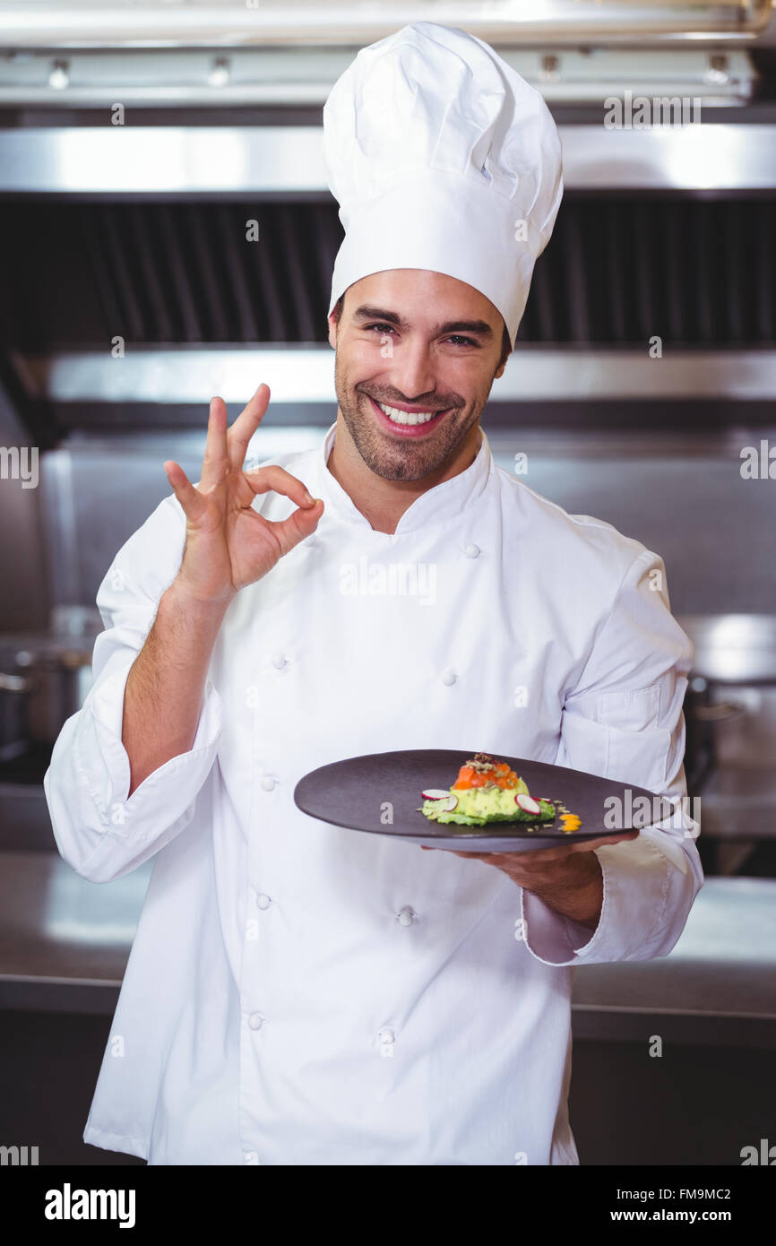 Male chef holding plate and doing ok sign Stock Photo - Alamy