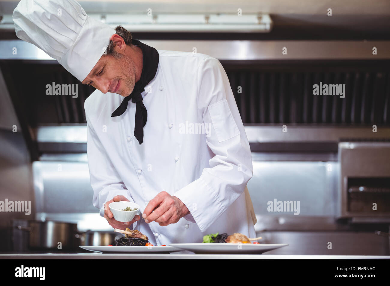 Chef sprinkling spices on dish Stock Photo - Alamy