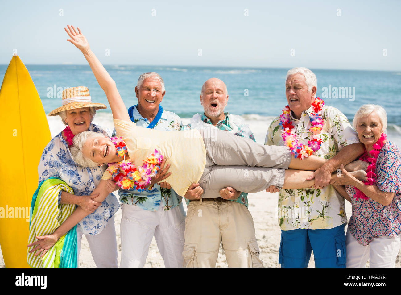 Seniors carrying senior woman Stock Photo - Alamy