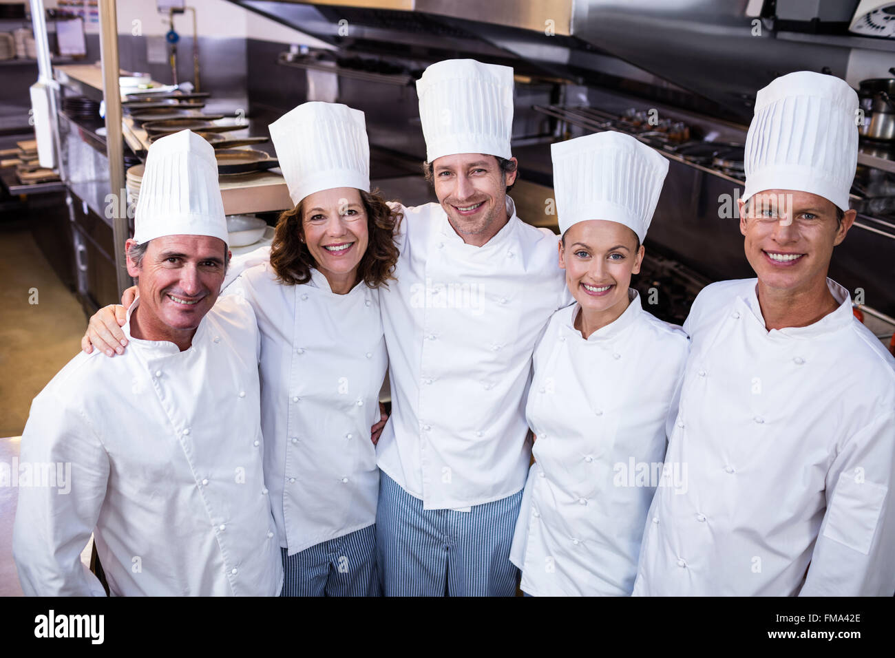 Happy chefs team standing together in commercial kitchen Stock Photo ...