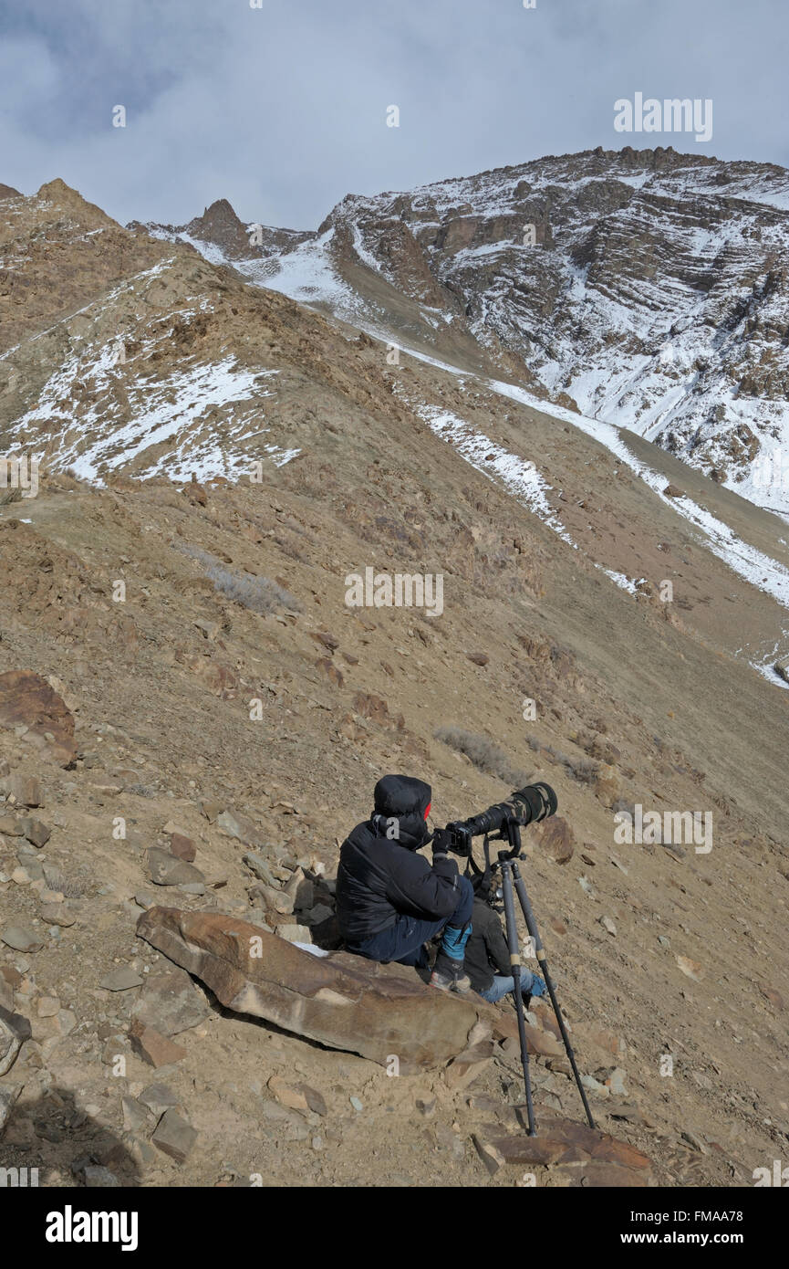 Nature photographers on the barren snow covered mountain slopes in the ...