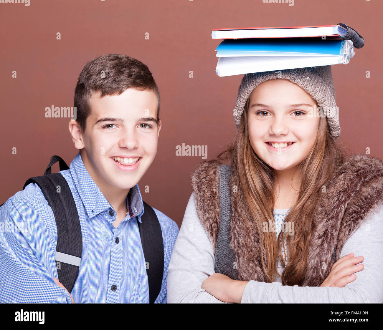 School kids standing looking to the camera and smiling on brown ...