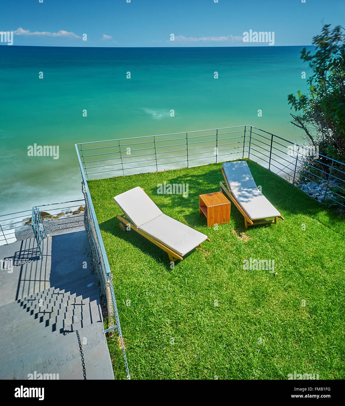 Seaside landscape with sea water, grass terrace and sunbed lounge Stock ...