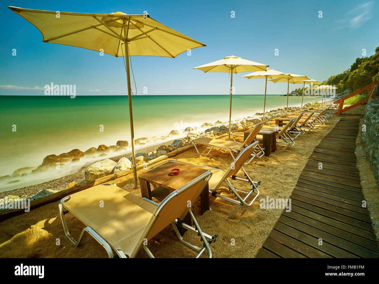 Seaside landscape with sand beach, sunbeds and umbrellas Stock Photo ...