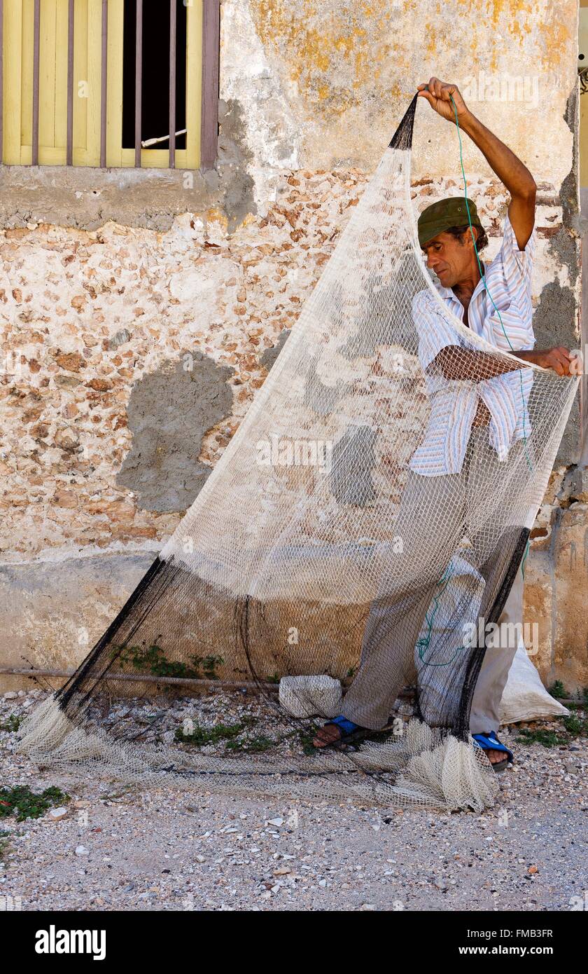 Cuba, Holguin, Gibara, Fisherman repairing his net Stock Photo - Alamy