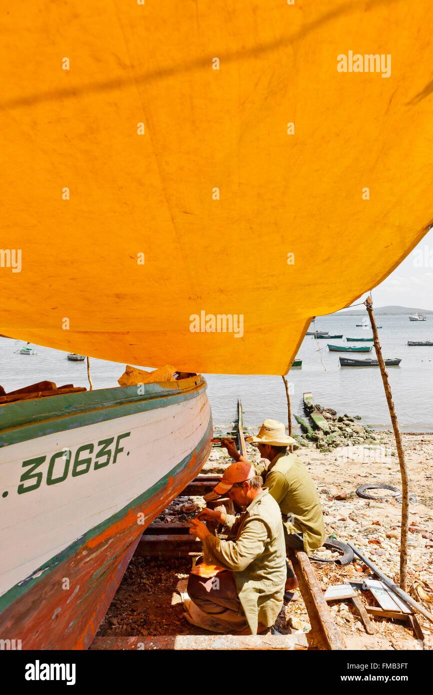 Cuba, Holguin, Gibara, Repainting their boat fishermen Stock Photo - Alamy