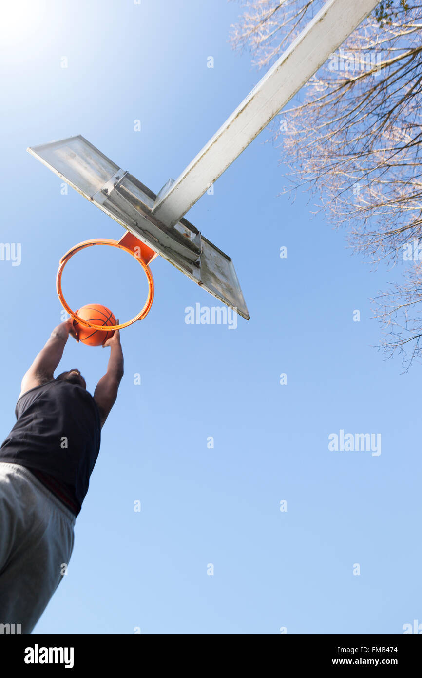 Basketball player jumping to dunk Stock Photo - Alamy
