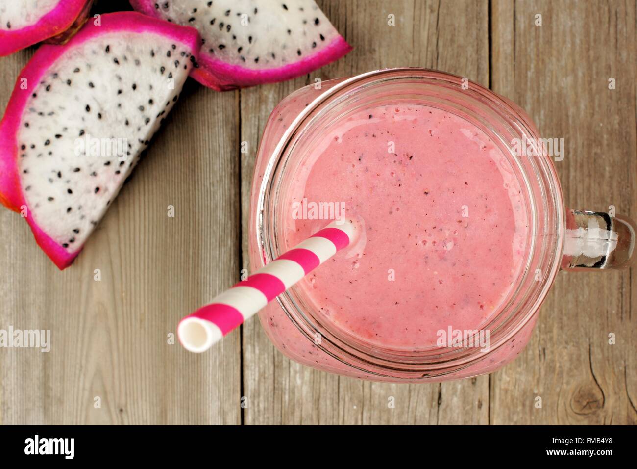Pink raspberry, dragon fruit smoothie with fruit slices on a wood ...