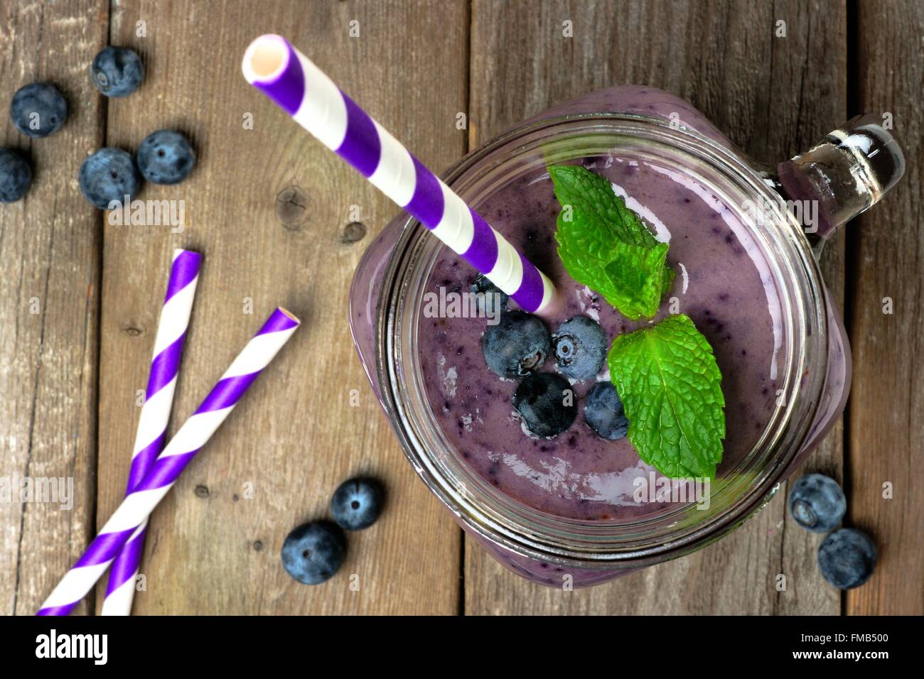 Blueberry smoothie with mint in mason jar mug with straw. Overhead view ...
