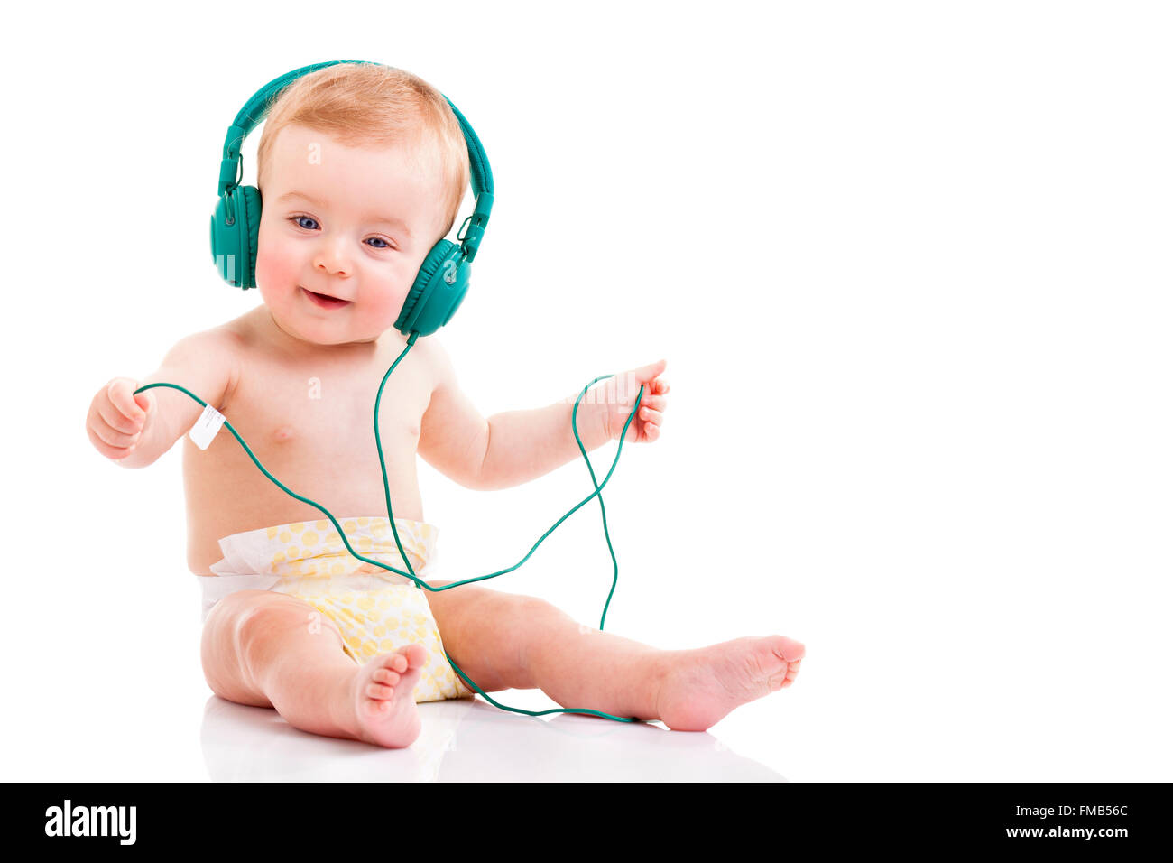 Happy baby with headphones listening to music on white background Stock ...
