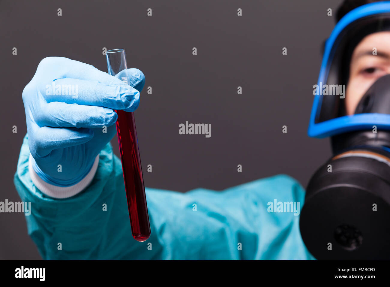 Scientist holding a sample of blood on grey background Stock Photo - Alamy