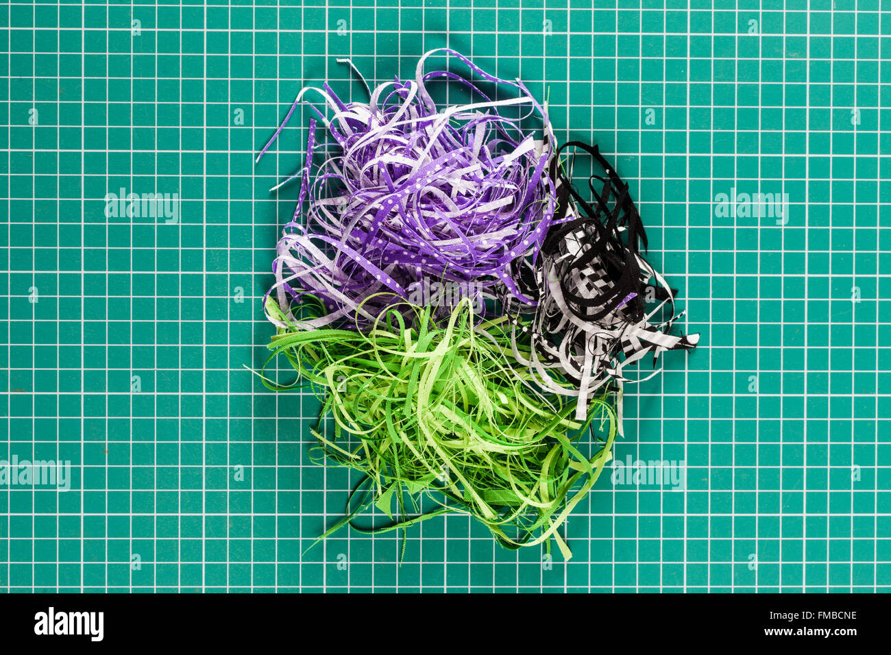 Textile offcuts on checkered green cutting mat Stock Photo - Alamy