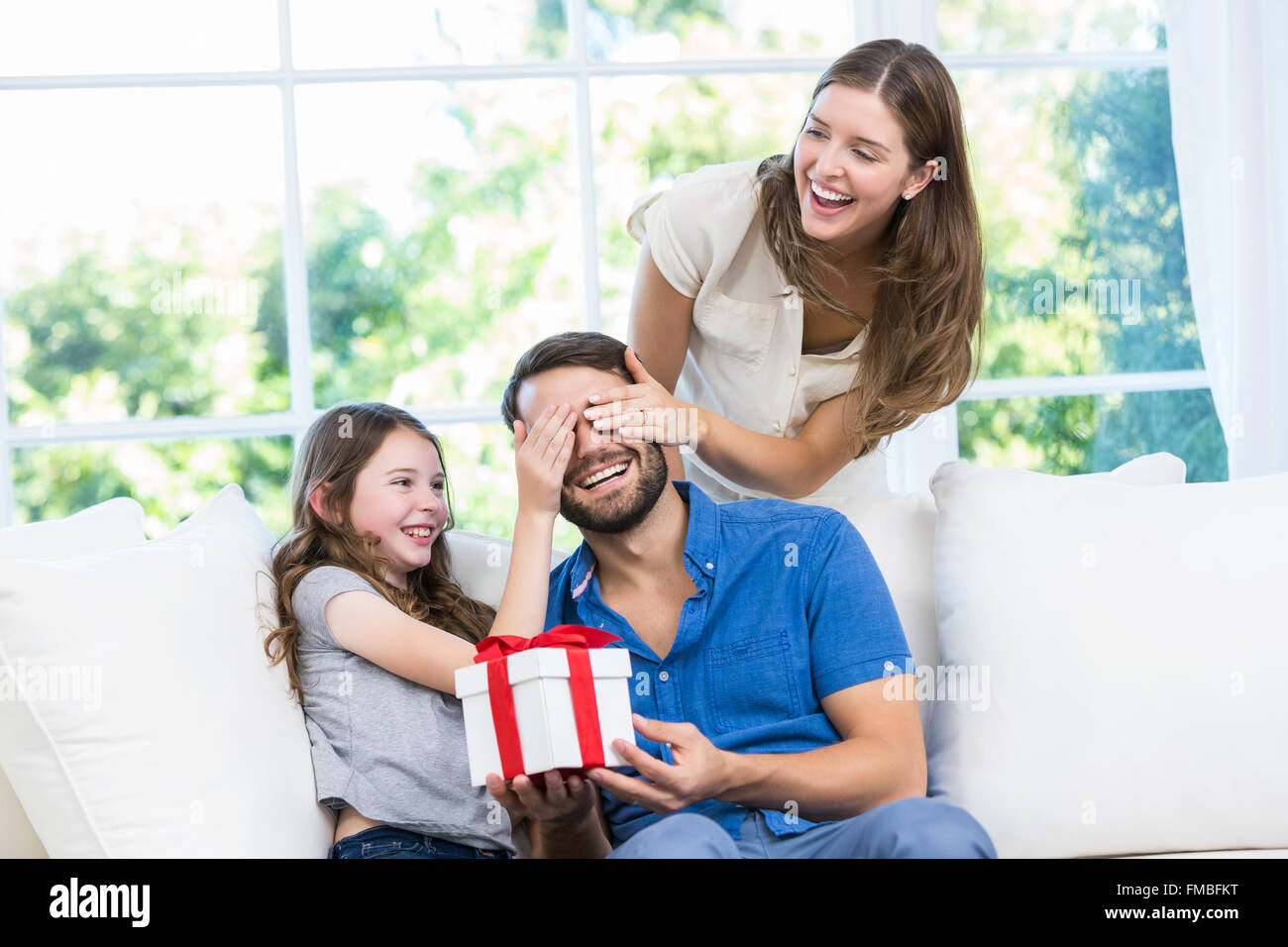 Man surprised with gift in sofa Stock Photo - Alamy