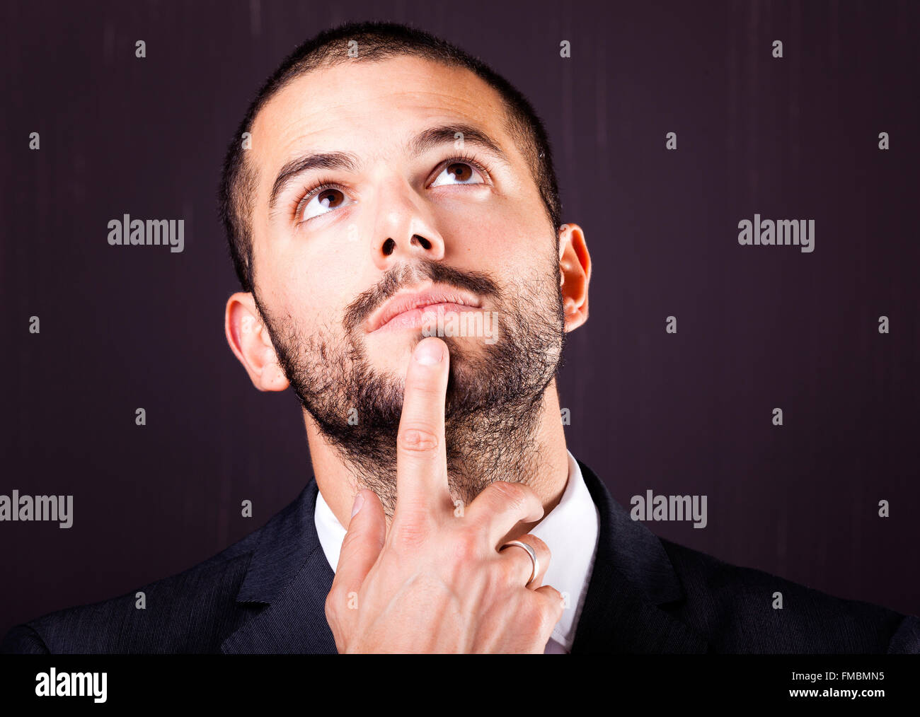 Young business man looking up over dark background Stock Photo - Alamy