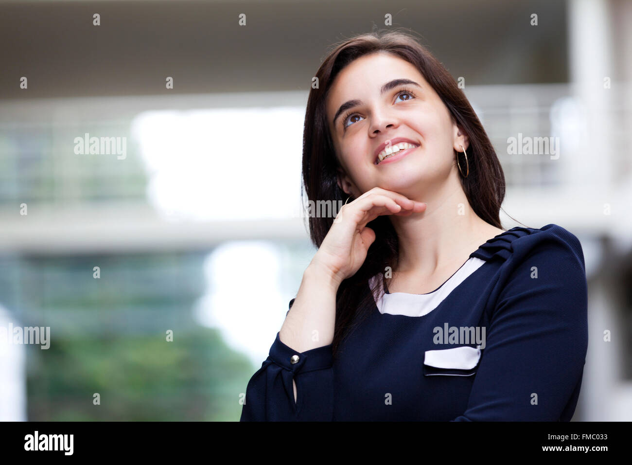 Business woman looking up at modern office building Stock Photo - Alamy