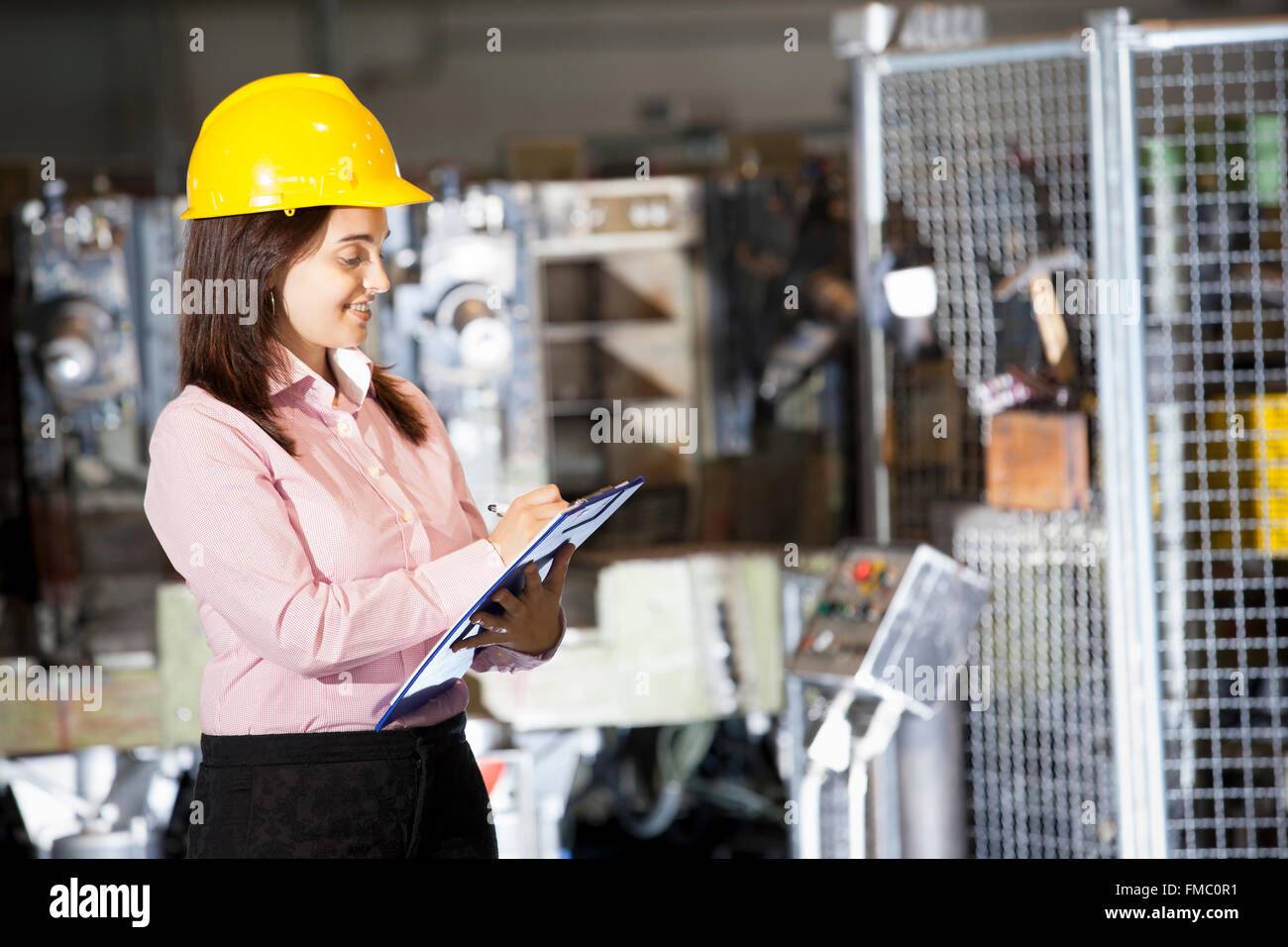 Mechanical engineer taking notes at metallurgy factory Stock Photo - Alamy
