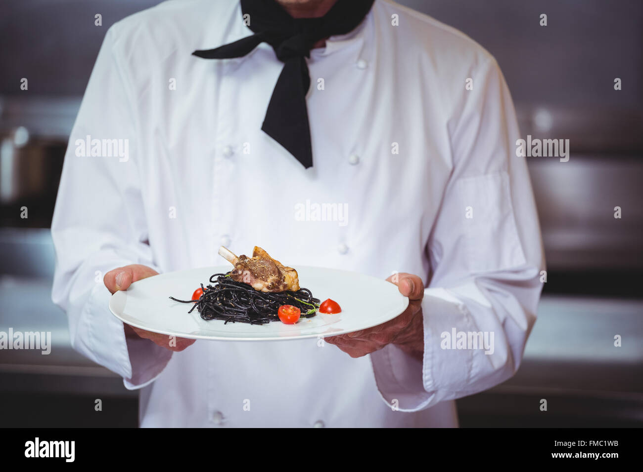 Chef holding a dish with spaghetti Stock Photo - Alamy