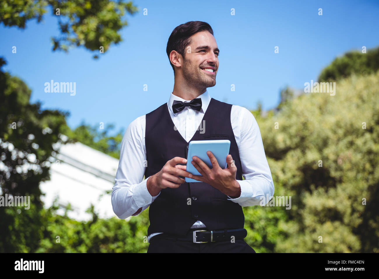 Handsome waiter using tablet computer Stock Photo - Alamy
